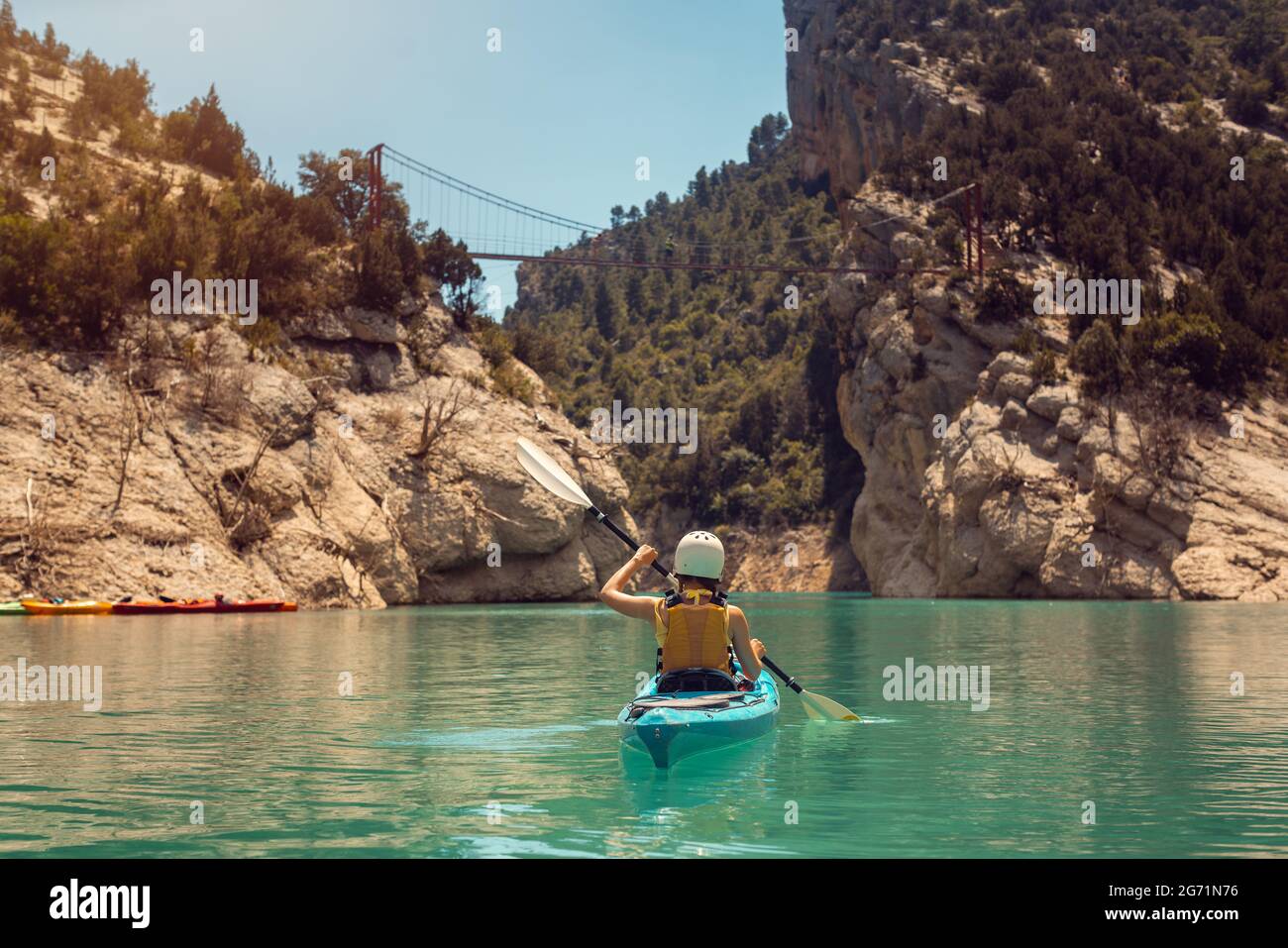 Woman in kayak on a river crossing a gorge in the Pyrenees mountains ...