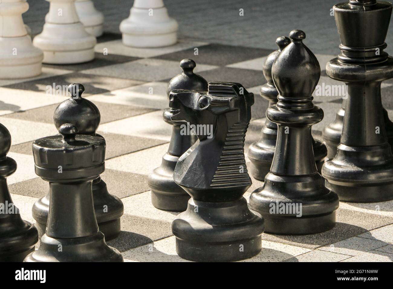 Chessboard in the street with a sun on huge chess pieces Stock Photo ...