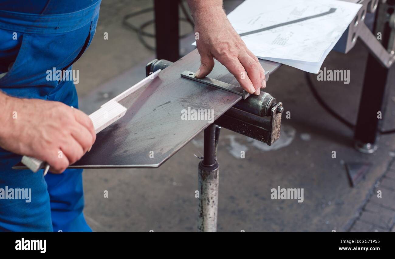 Metalworker measuring a strip of steel for his next project Stock Photo ...