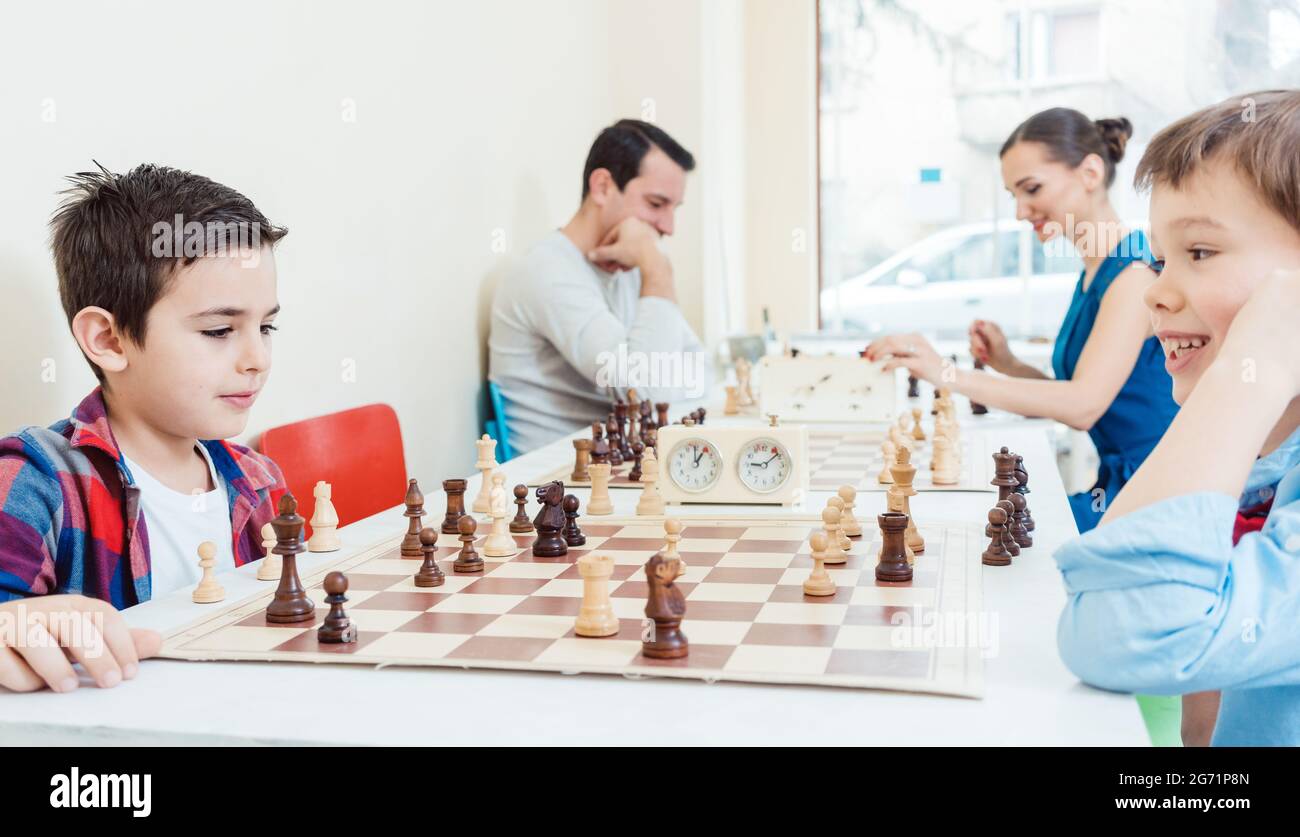 Family playing chess in tournament room learning the game Stock Photo ...