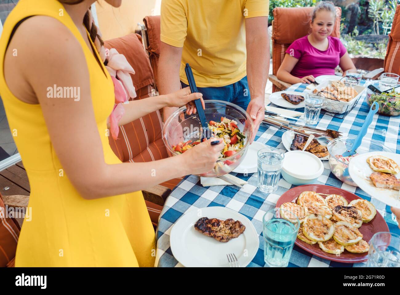 Family eating meat and salad during garden party Stock Photo - Alamy