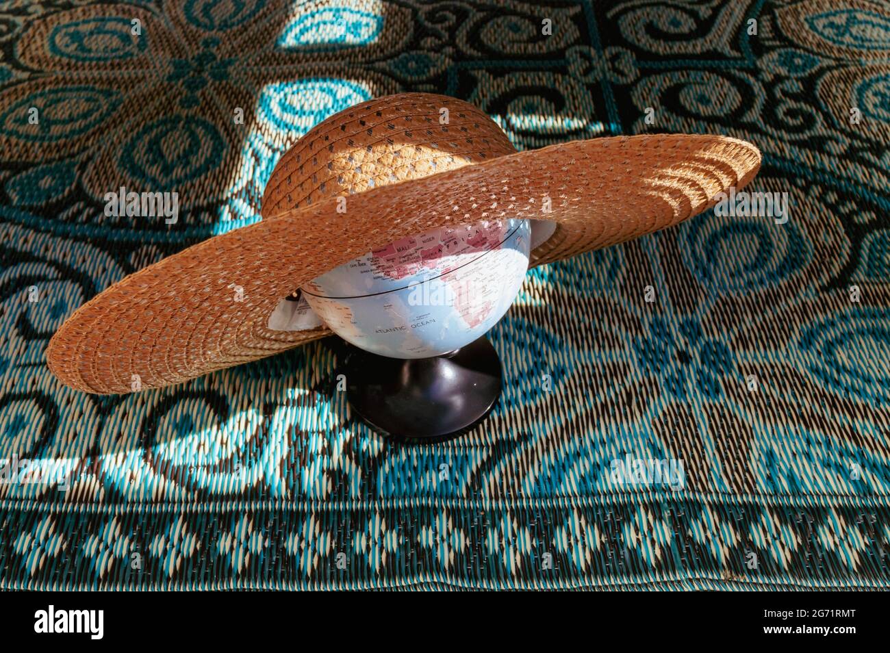 Image of a small world globe wearing a summer hat made out of straw on ...