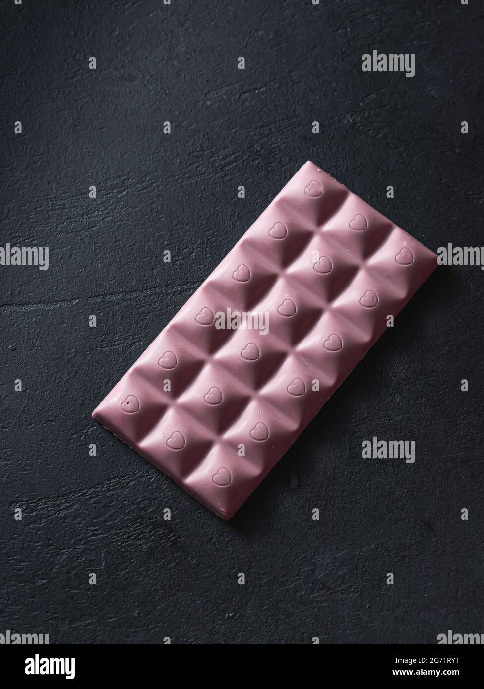 Pink chocolate on a black background. Ruby chocolate. The fourth type ...