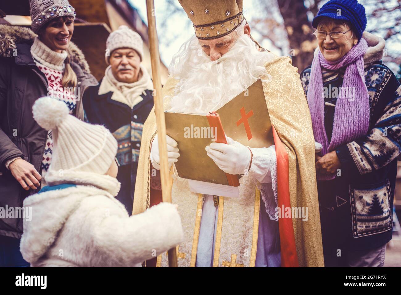 St Nicholas reading stories from the Bible to a child Stock Photo - Alamy