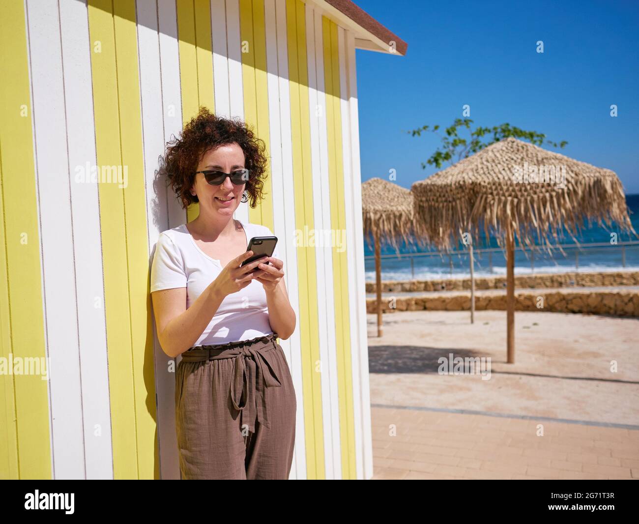 Woman using the phone during her summer vacation Stock Photo - Alamy