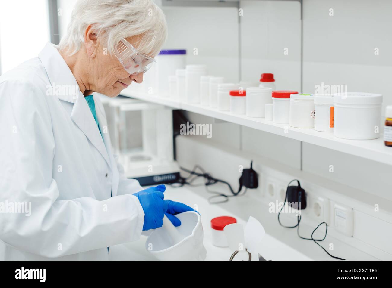 Absorbed Pharmacist woman mixing some drug or medicine in laboratory ...