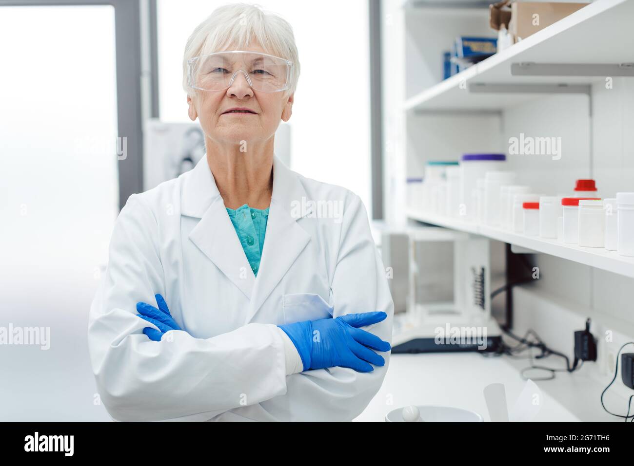 Experienced chemist standing in laboratory of pharmacy looking into the ...