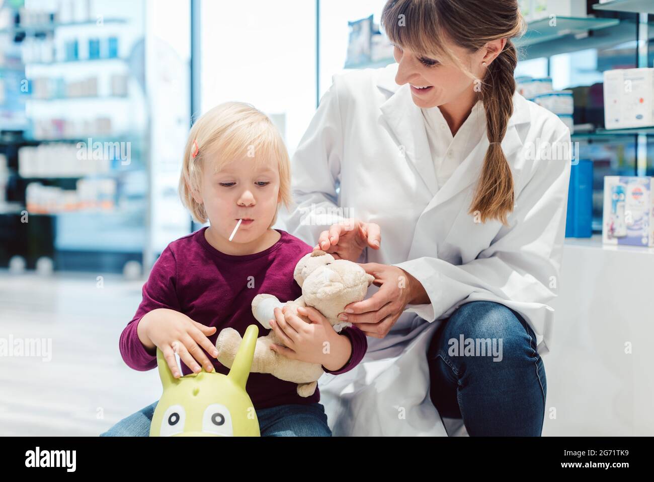 Little girl child in the pharmacy talking to the chemist sitting on a ...