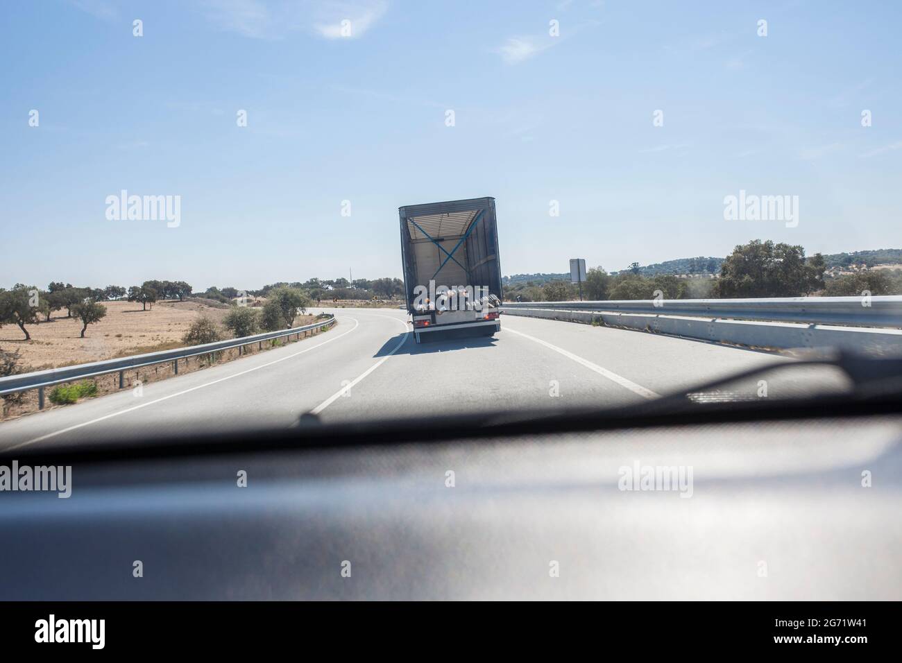 Driving behind building materials truck loaded with steel framework ...