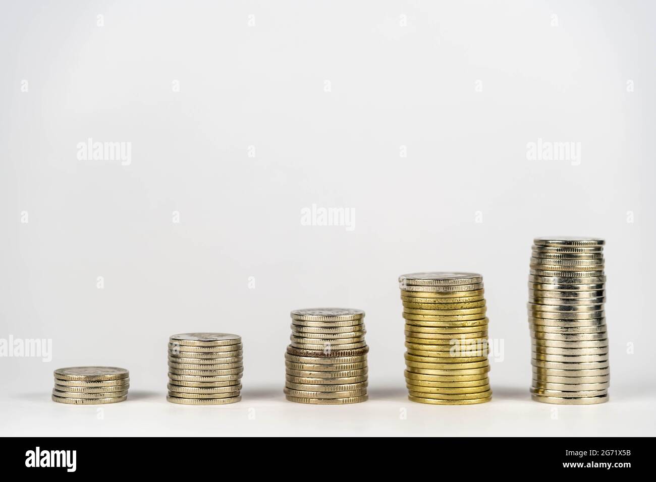 Five stacks of golden coins with different heights arranged in growing ...