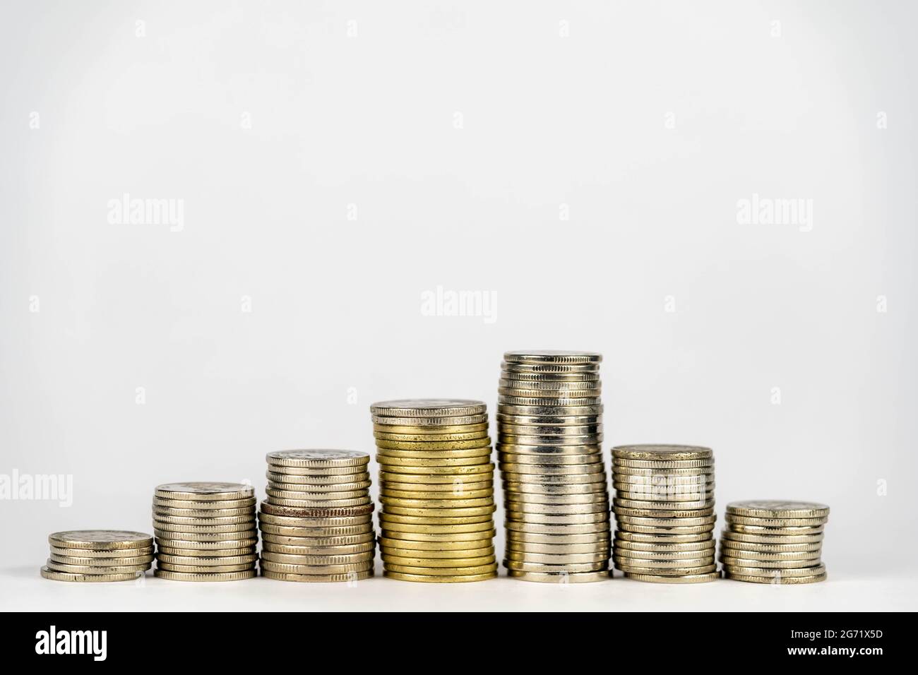 Seven stacks of golden coins with different heights arranged in growing ...