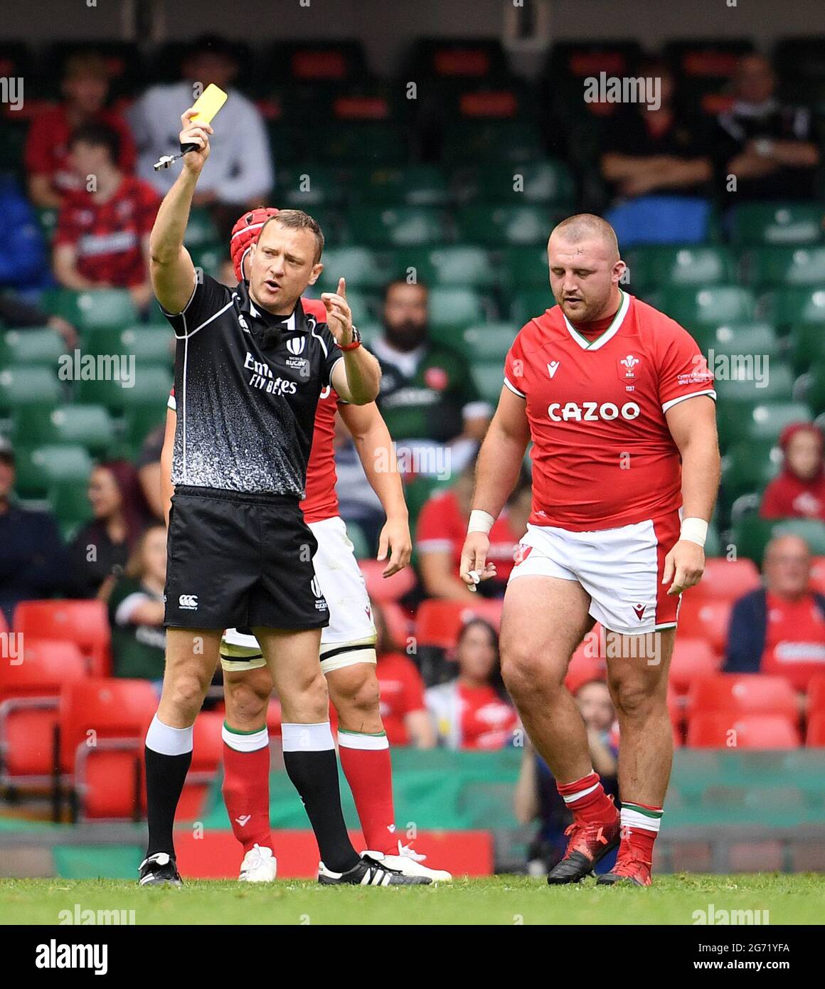 Referee Matthew Carley shows a yellow card to Wales' Dillon Lewis ...
