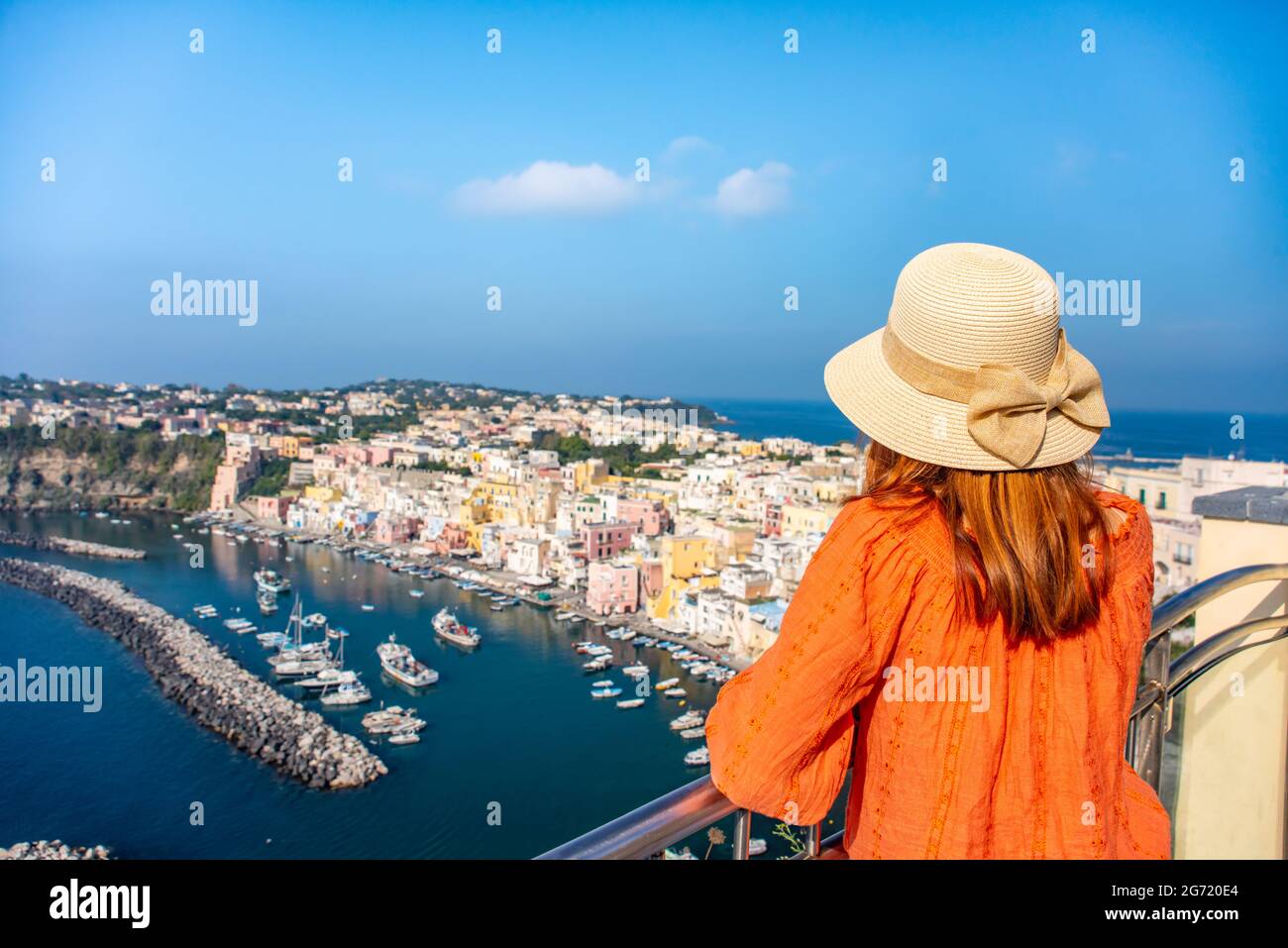 Beautiful young girl over panoramic view of Procida Island, Naples ...