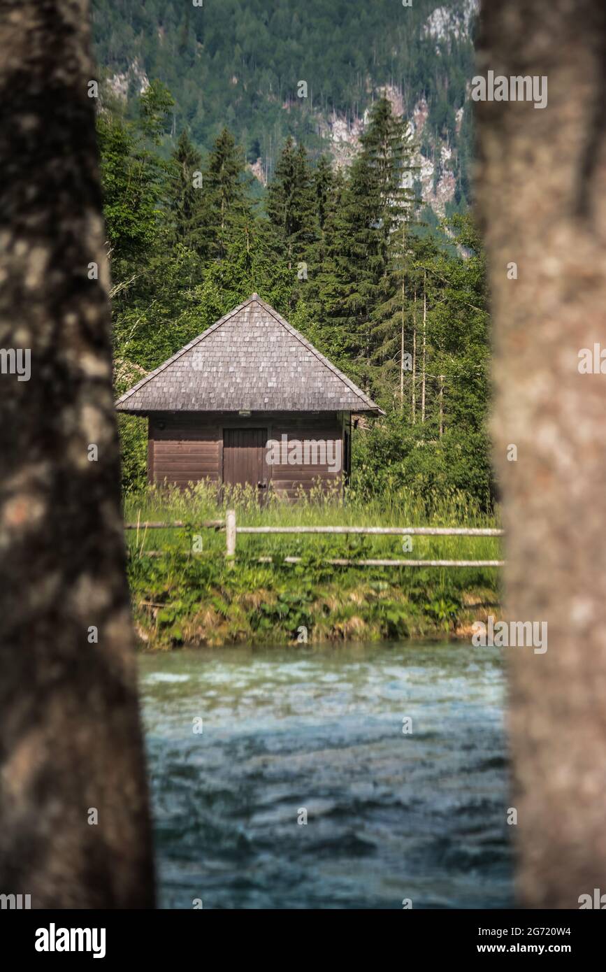 Vertical shot of a small wooden cottage surrounded by a river on a ...