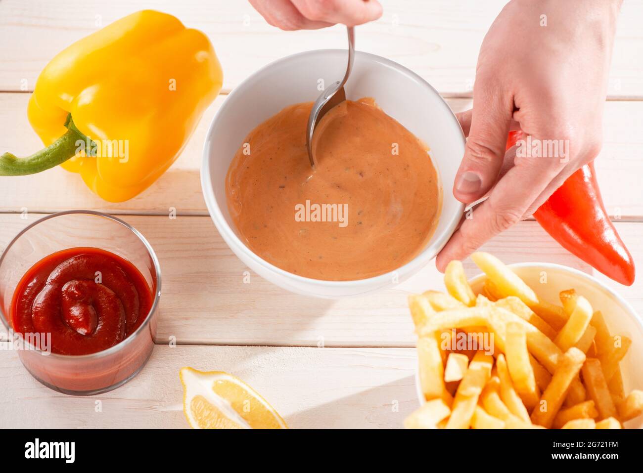 Top view on a hand mixing sauce andalouse with a spoon Stock Photo - Alamy