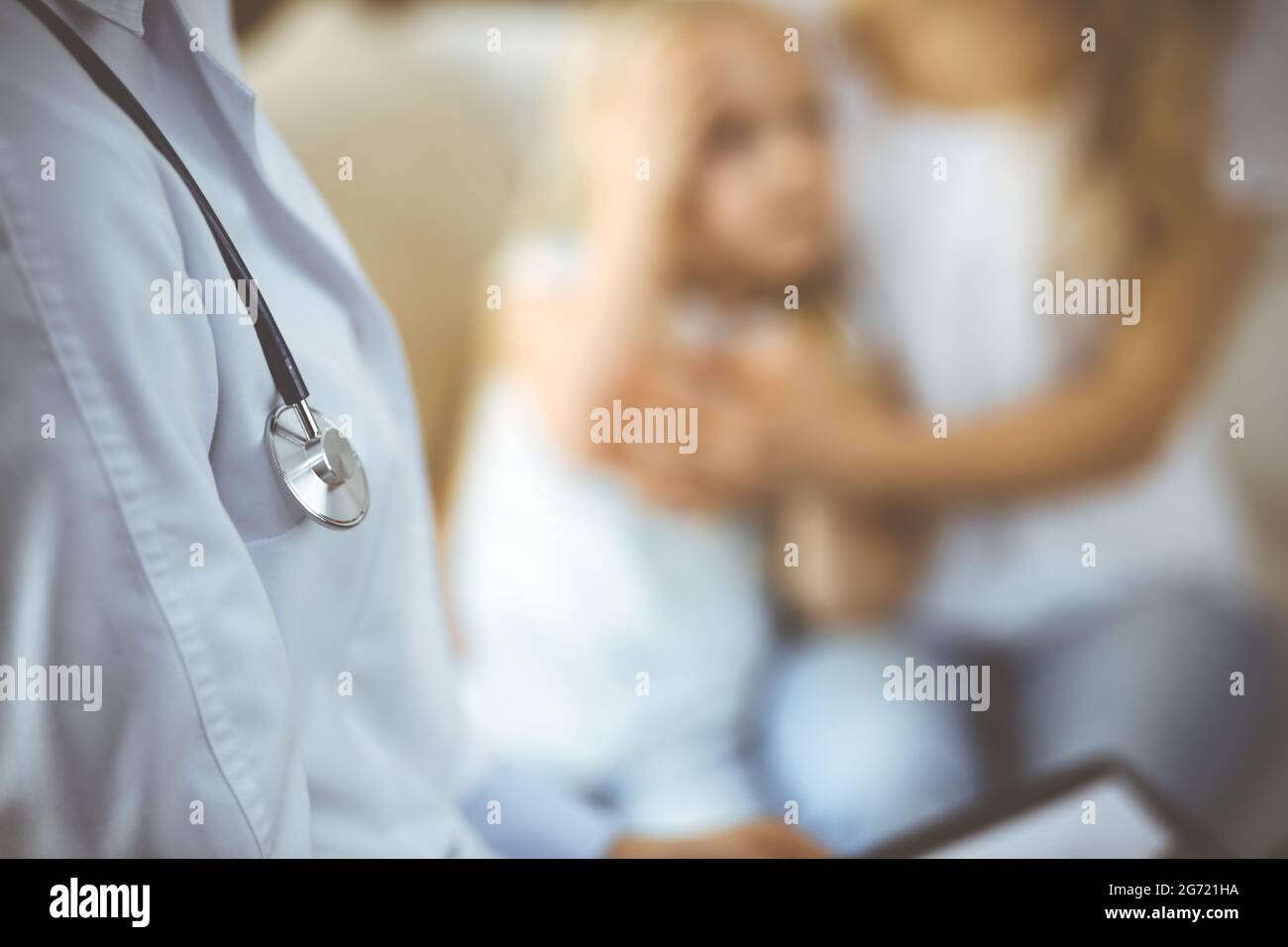 Doctor and patient. Pediatrician using clipboard while examining little ...