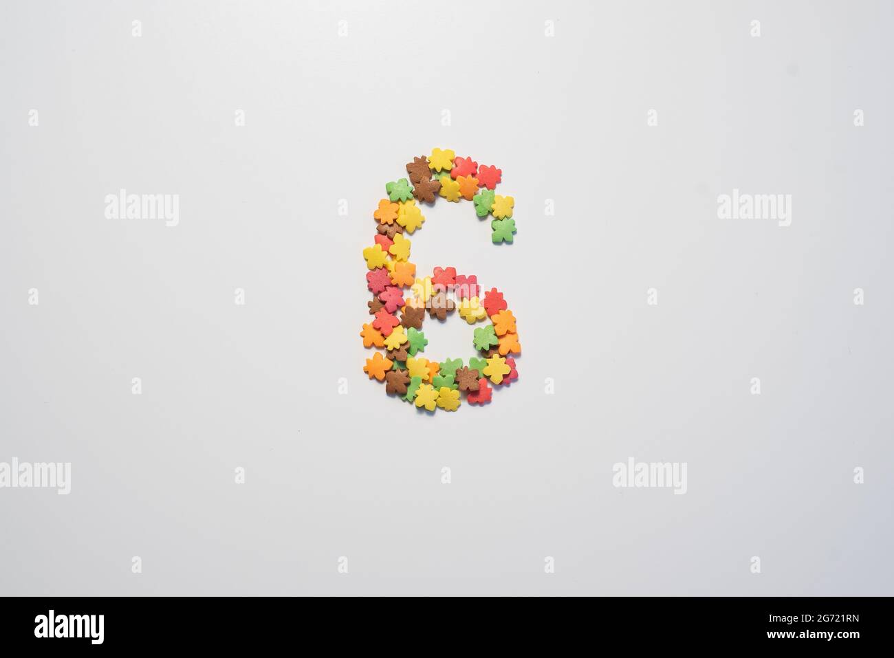 Number six from sweet pastry topping in the form of colorful foliage on ...