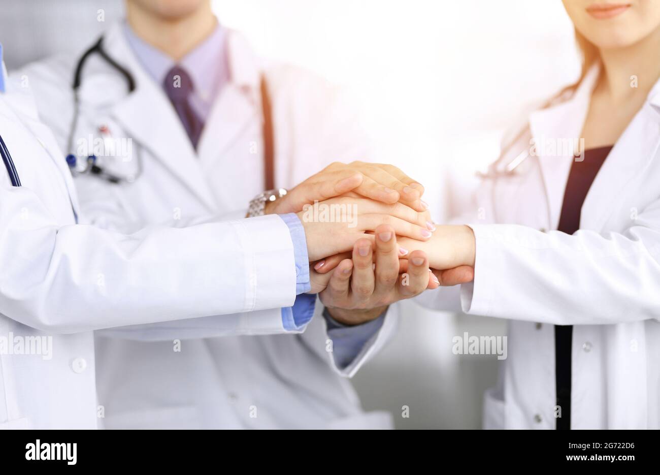Group of modern doctors joining hands as a circle and ready to help ...