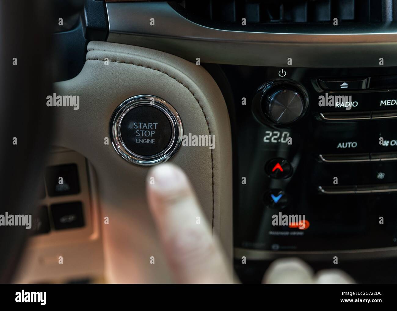 Finger pressing button the start button, stop the engine in the luxury ...
