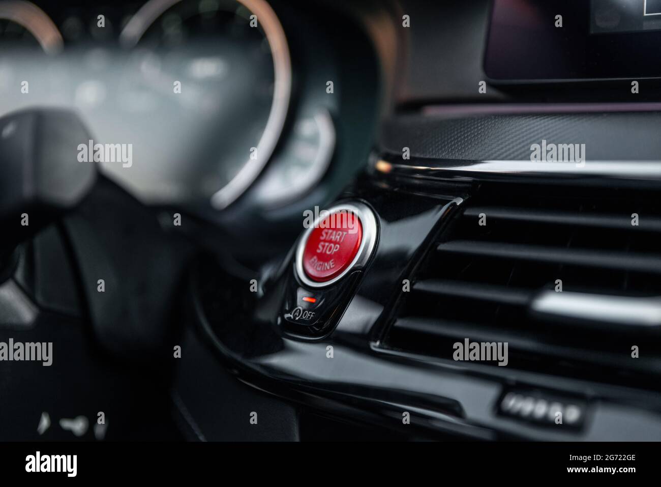 Sports car dashboard with focus on red engine start stop button. Button ...