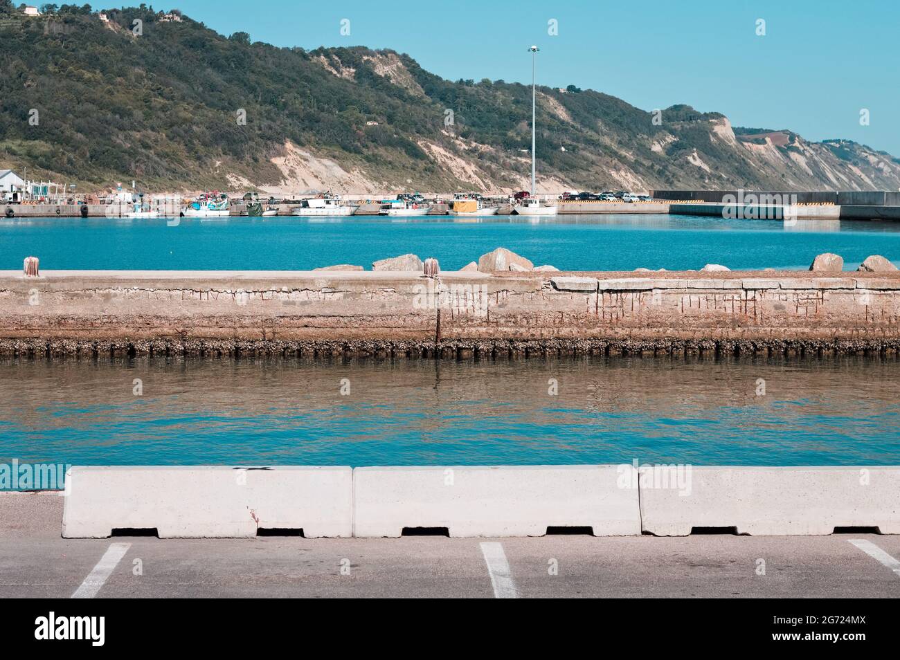 A reinforced concrete pier with concrete spalling in the port of Pesaro ...