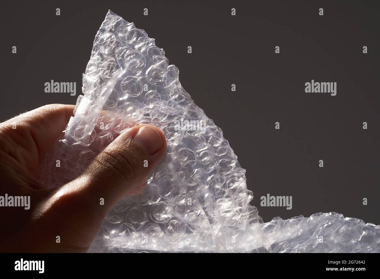 Close-up of a man's hand bursting bubbles from a bubble wrap Stock ...