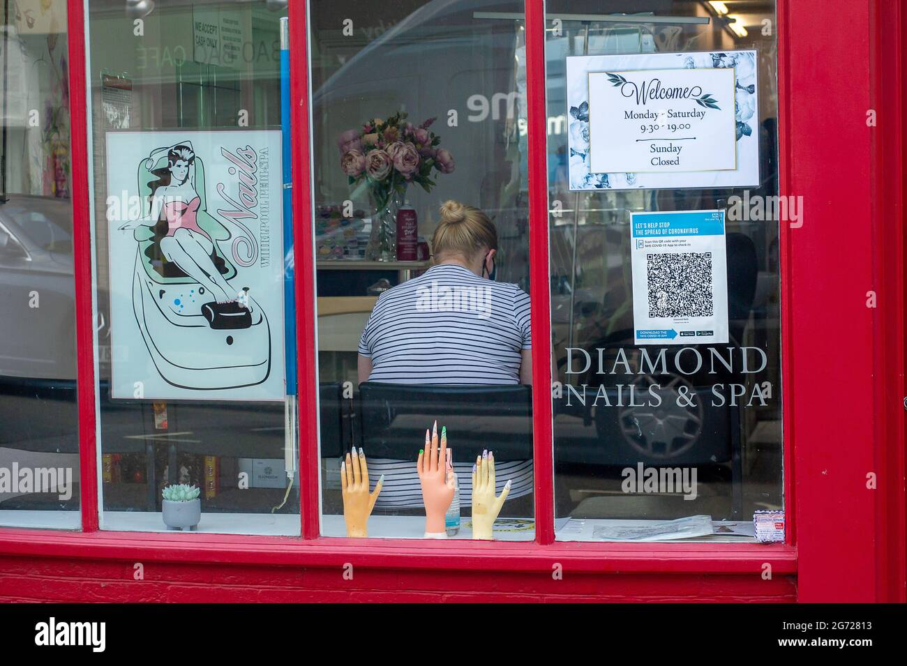 A lady sits in a nail bar waiting for her appointment during the Covid ...