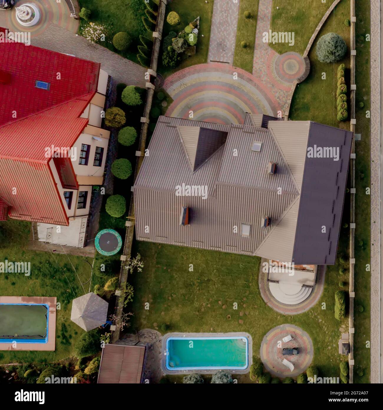 Aerial top view of a private house with paved yard with green grass ...