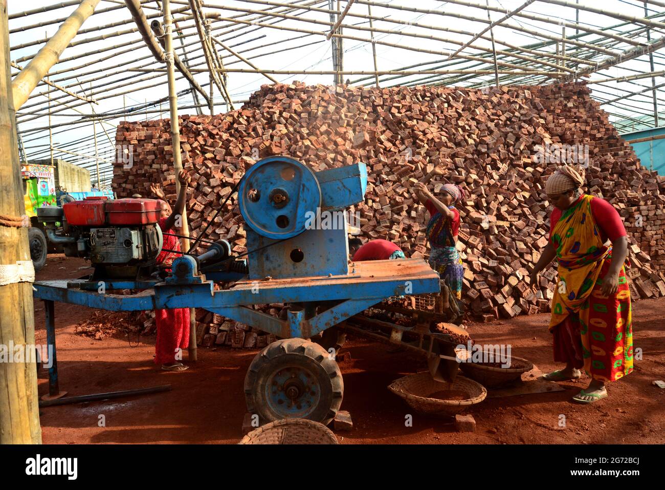 Bangladeshi day labor busy to crushing bricks with a machine during ...