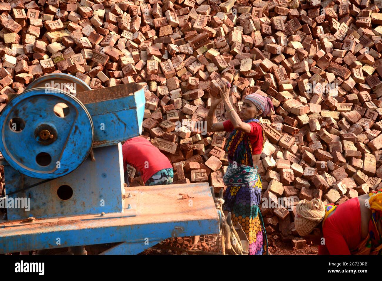 Bangladeshi day labor busy to crushing bricks with a machine during ...