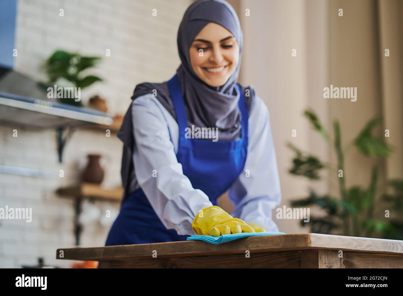 Portrait of smiling Muslim woman cleaning a house Stock Photo - Alamy
