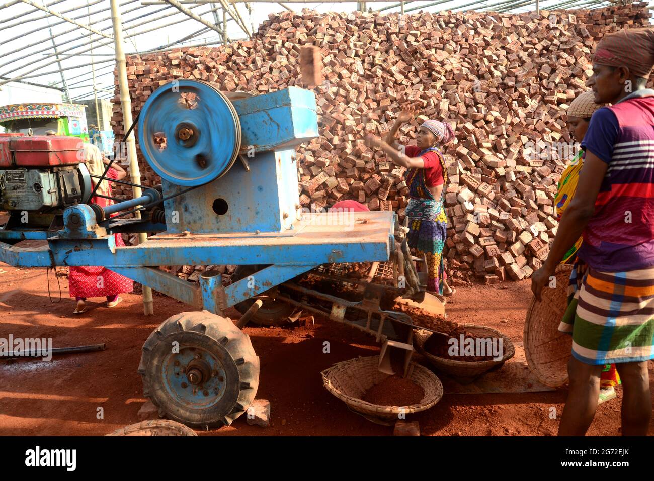 Bangladeshi day labor busy to crushing bricks with a machine during ...