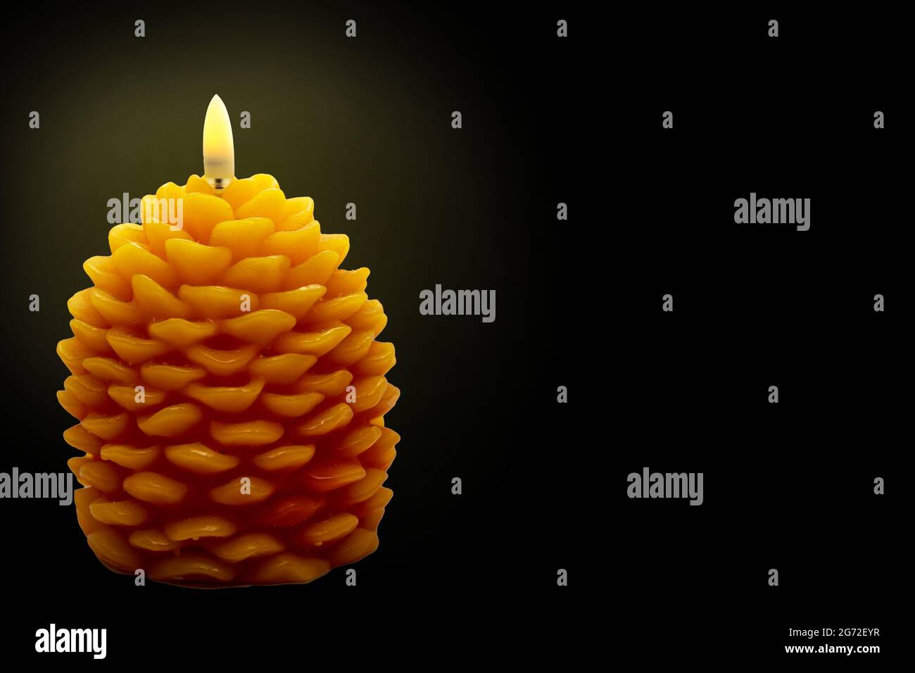 A vibrant pine candle with naturally formed structure lit or burning ...
