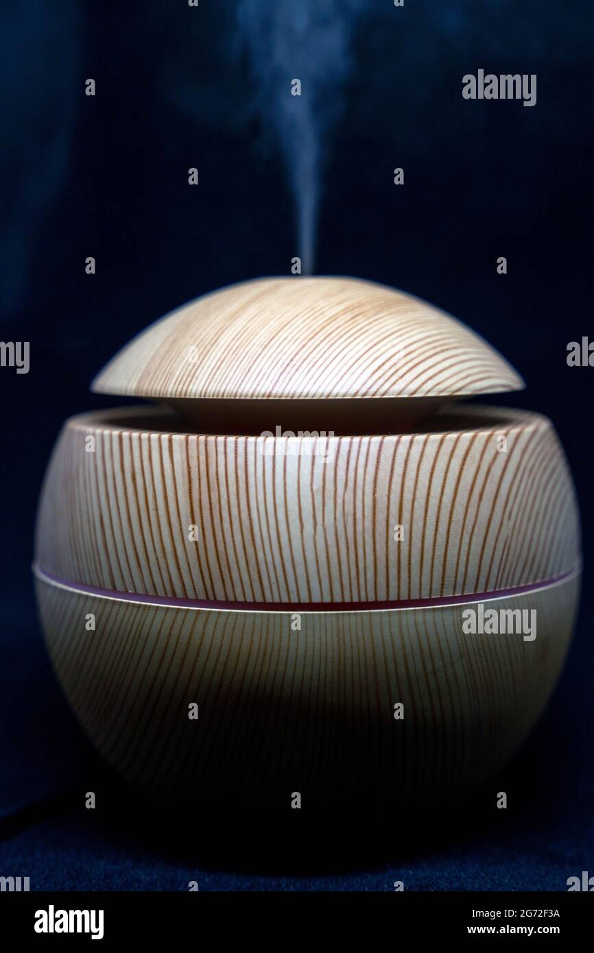 A round wooden texture Humidifier spreading steam into the living room ...