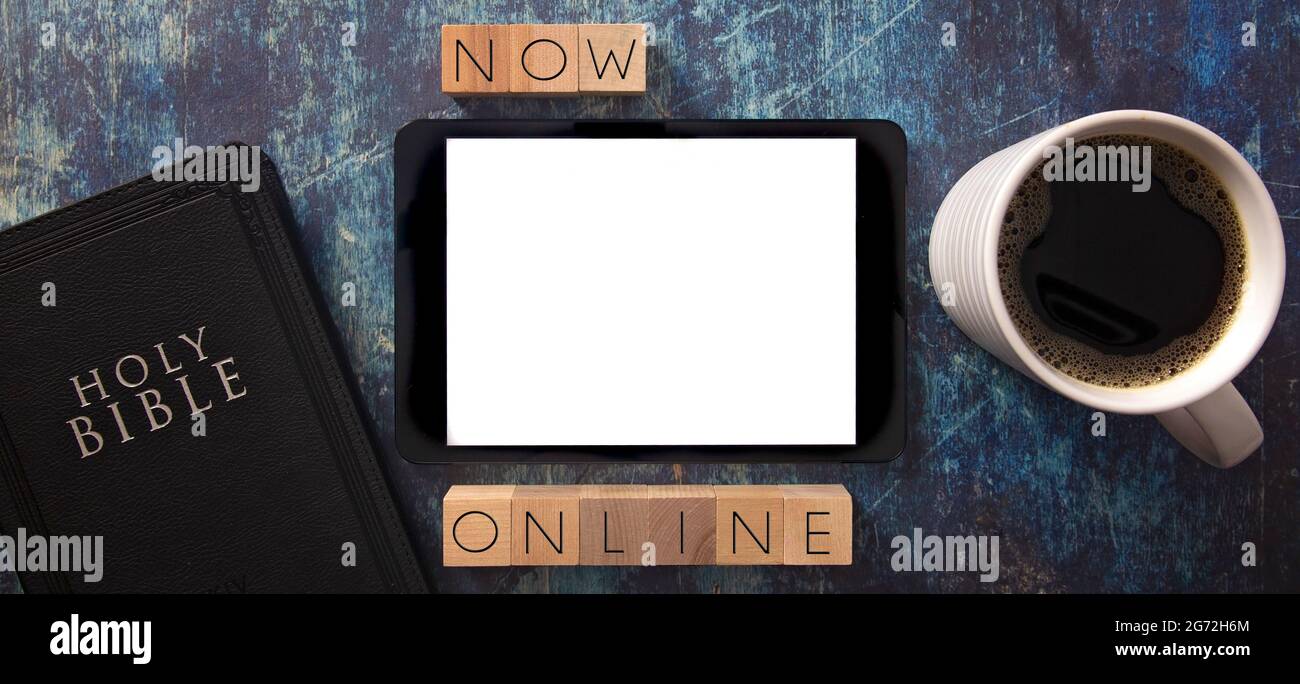 Now Online in Block Letters on a Wooden Table with a Bible and Tablet ...