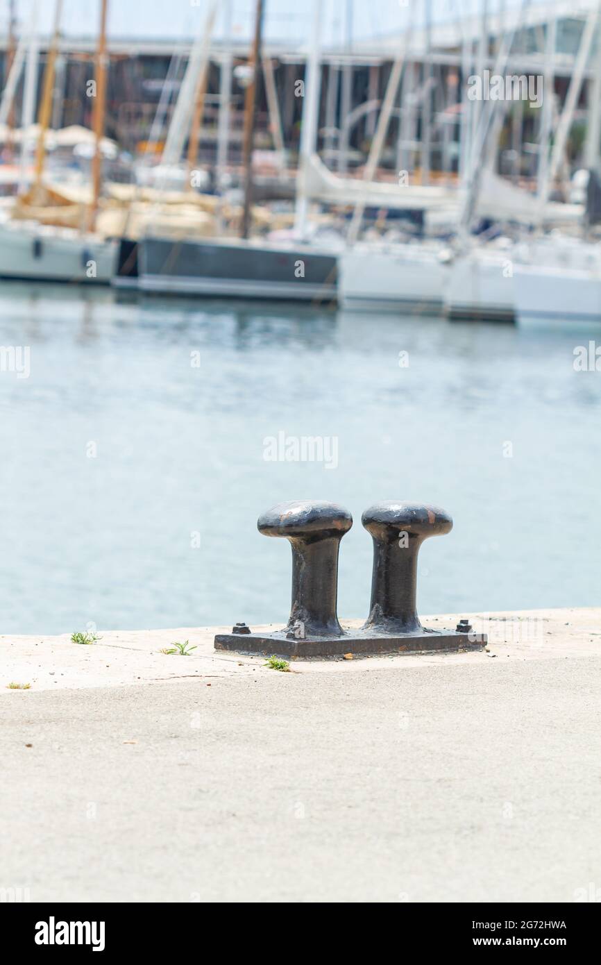 Vertical shot of iron pivot for mooring ships with sailboats background ...