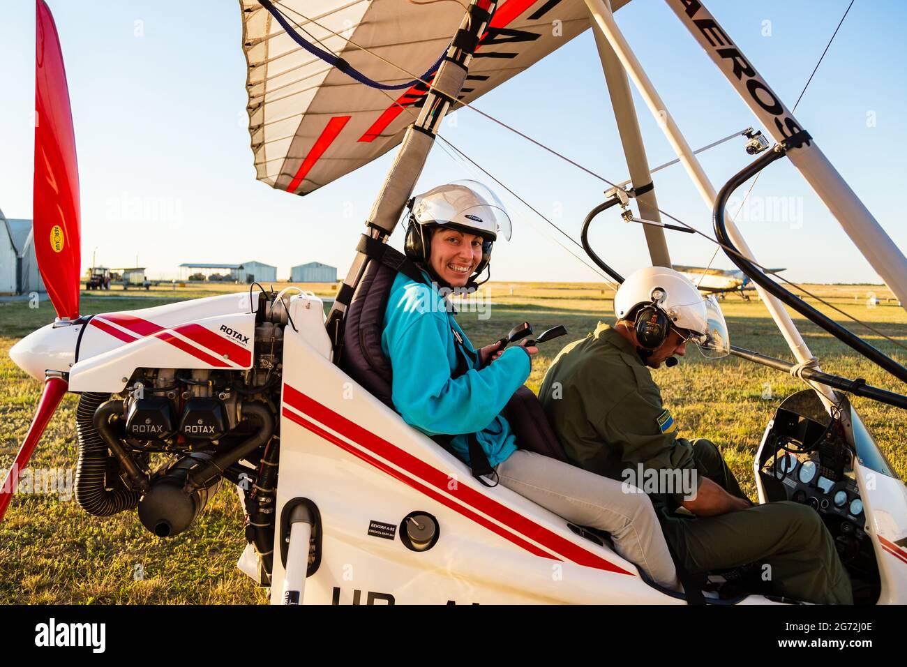Odessa, Ukraine - July 14, 2016: Young happy girl with pilot preparing to start the flight at ...