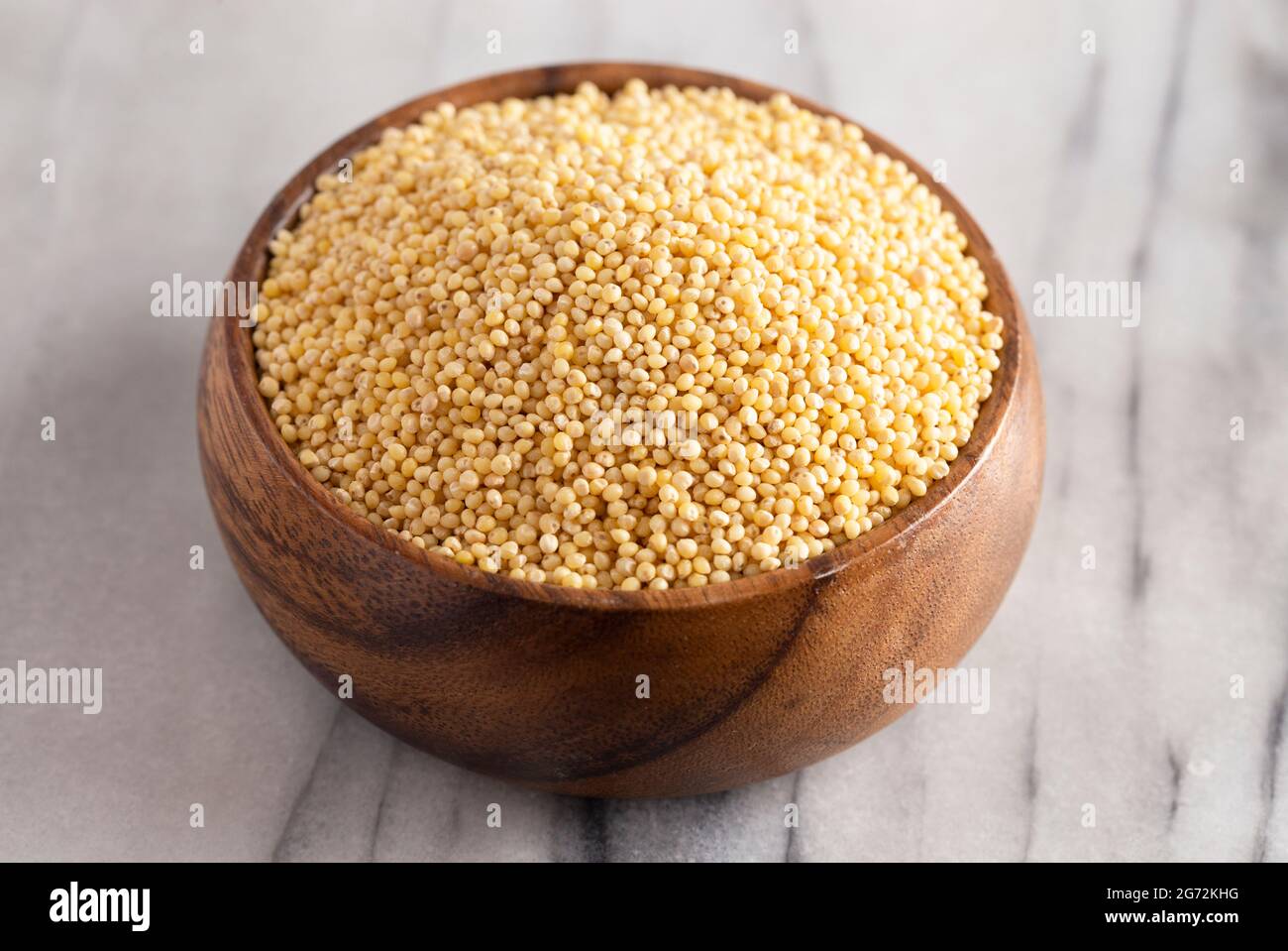 A Bowl of Whole Millet in a Wood Bowl on a White Marble Counter Stock ...