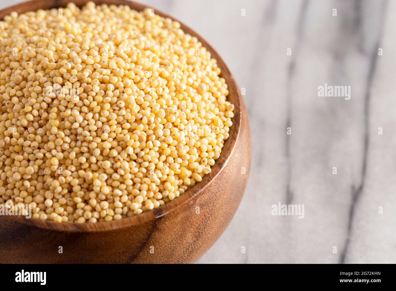 A Bowl of Whole Millet in a Wood Bowl on a White Marble Counter Stock ...