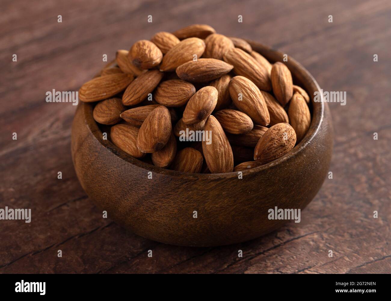 A Bowl Full of Raw Natural Almonds on a Dark Wood Table Stock Photo - Alamy