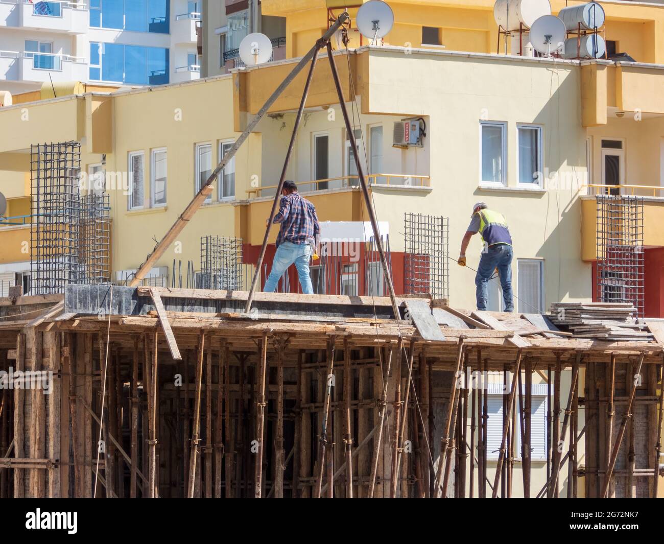 Two workers on the construction of a residential multi-storey building ...
