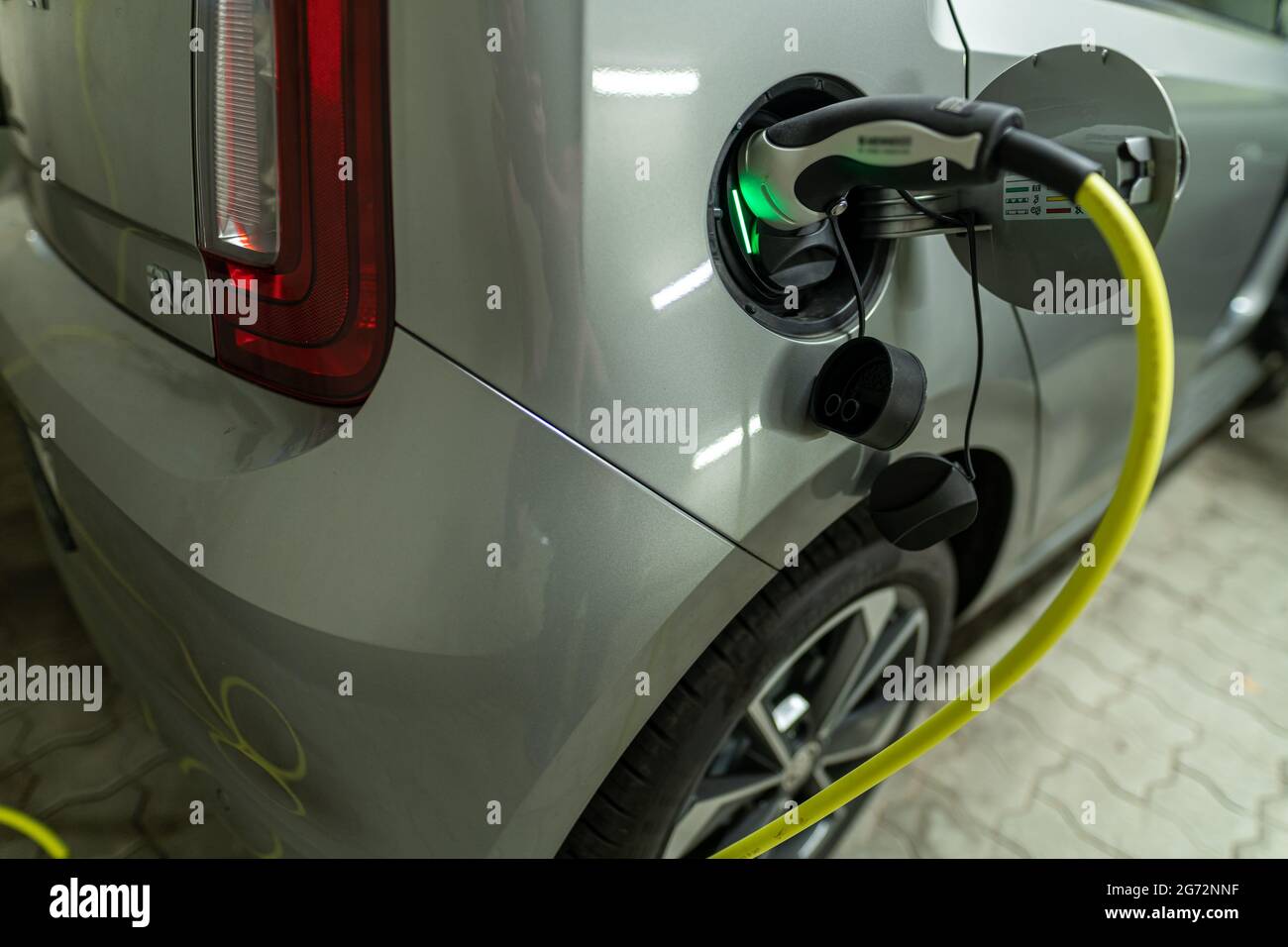 View at a charging electric car by a pluged in type 2 charging wire ...
