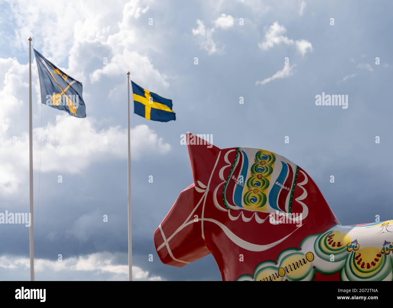 A horizontal view of a colorful Swedish Dala horse and the Swedish flag ...