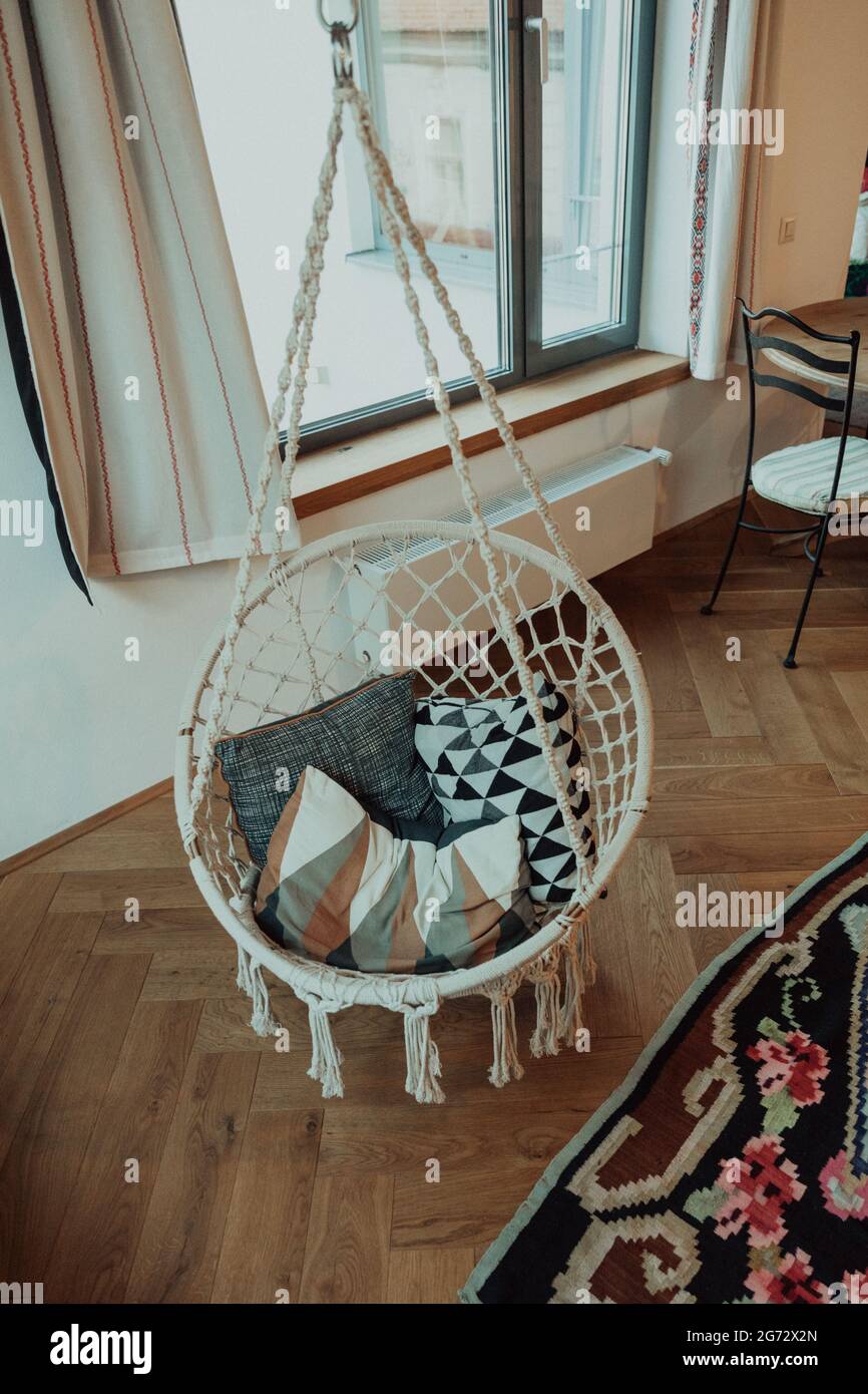 Vertical shot of a macrame hanging chair in a loft-style room Stock ...