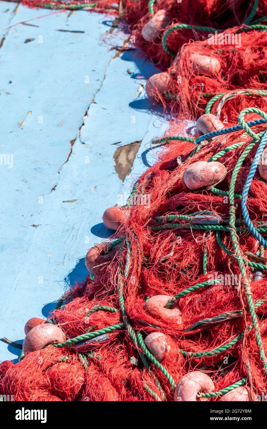pile of red fishing nets on wooden background of a boat with copy space ...