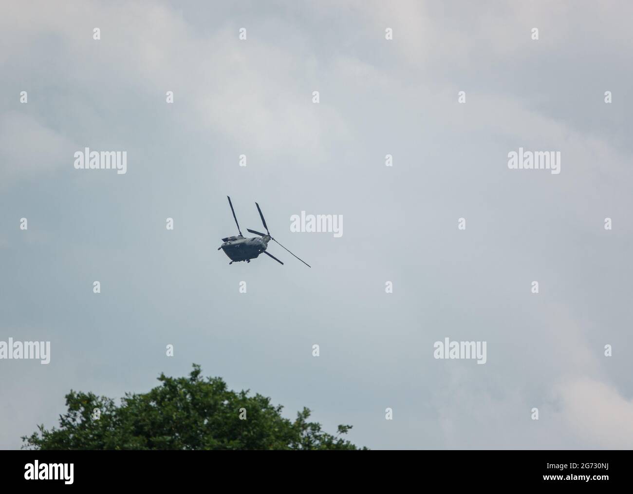RAF Chinook tandem-rotor CH-47 helicopter flying fast and low, banking ...