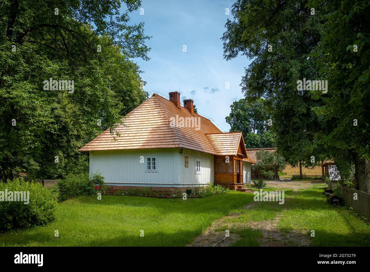 Old farm buildings and a court surrounded by trees in a countryside ...