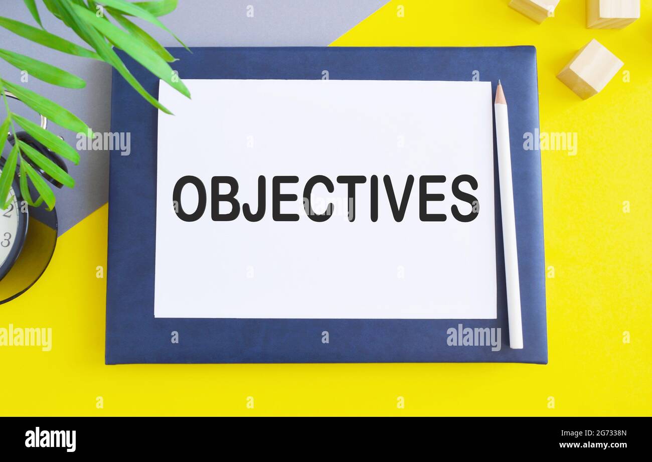 Hand writing Objectives to do list on white paper above Notebook ...