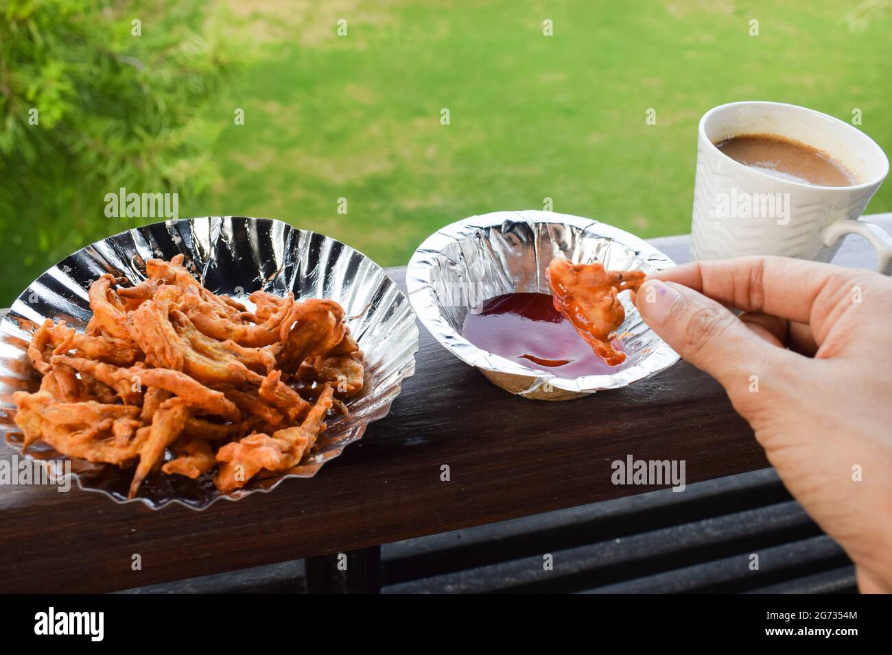 Female eating tasty Onion pakoda or pyaz ke pakode, bhajiya. Indian ...