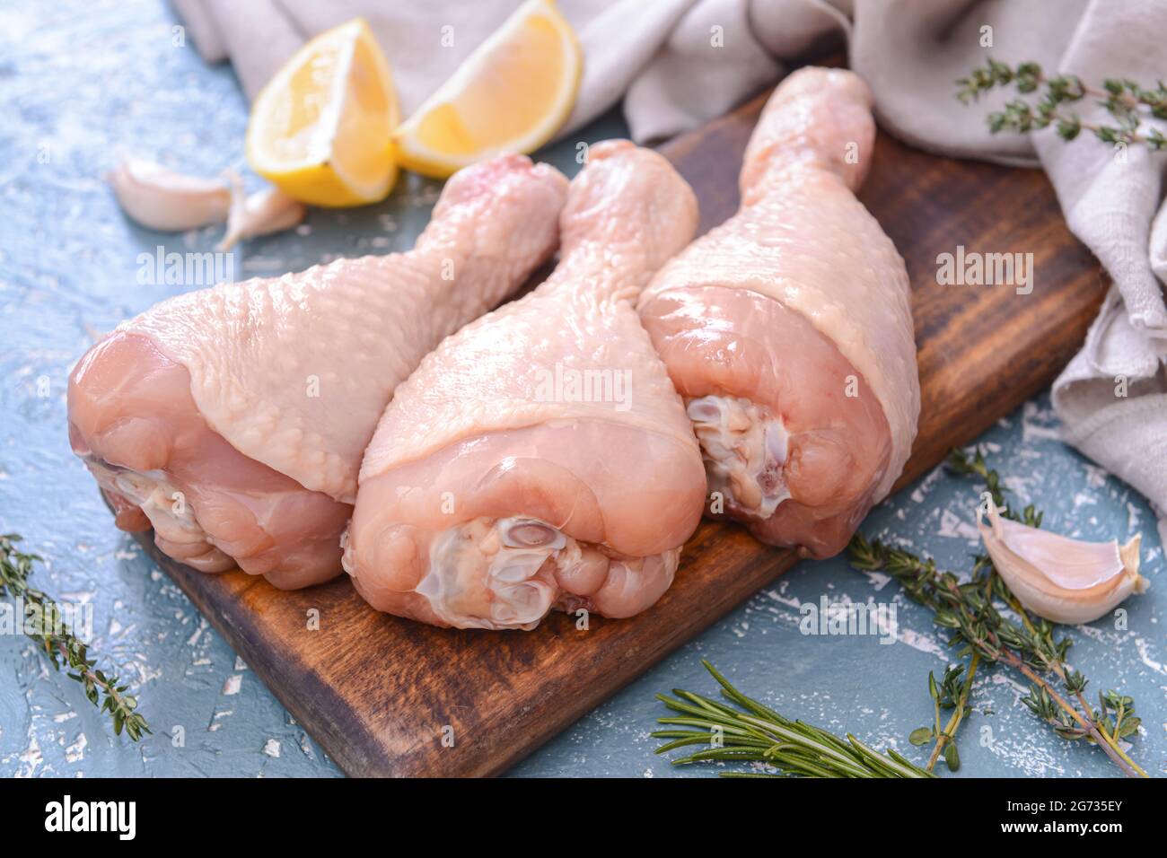 Board with raw chicken legs on color background Stock Photo - Alamy